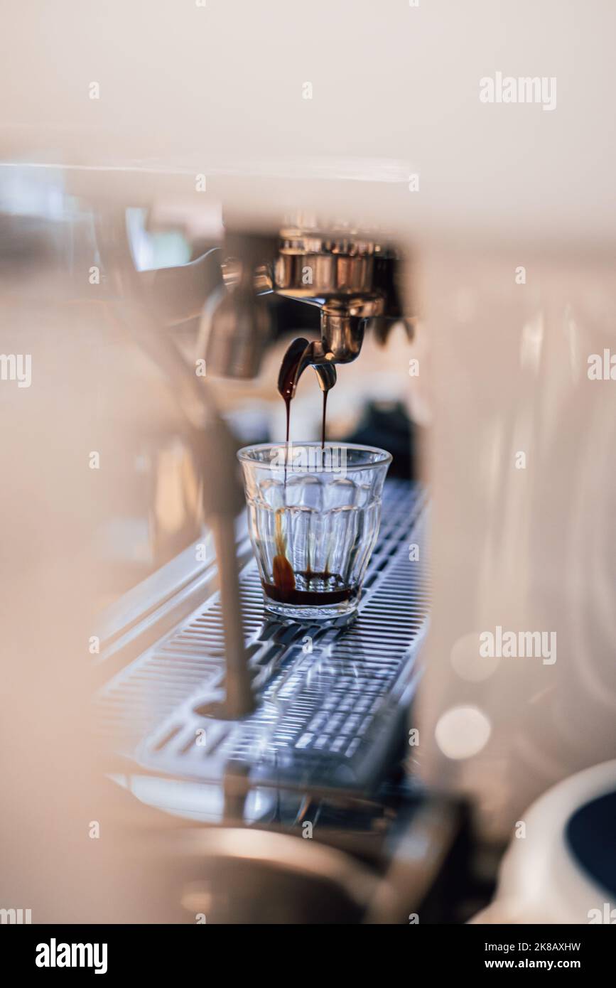 Coffee dripping in a transparent glass from a coffee machine Stock ...