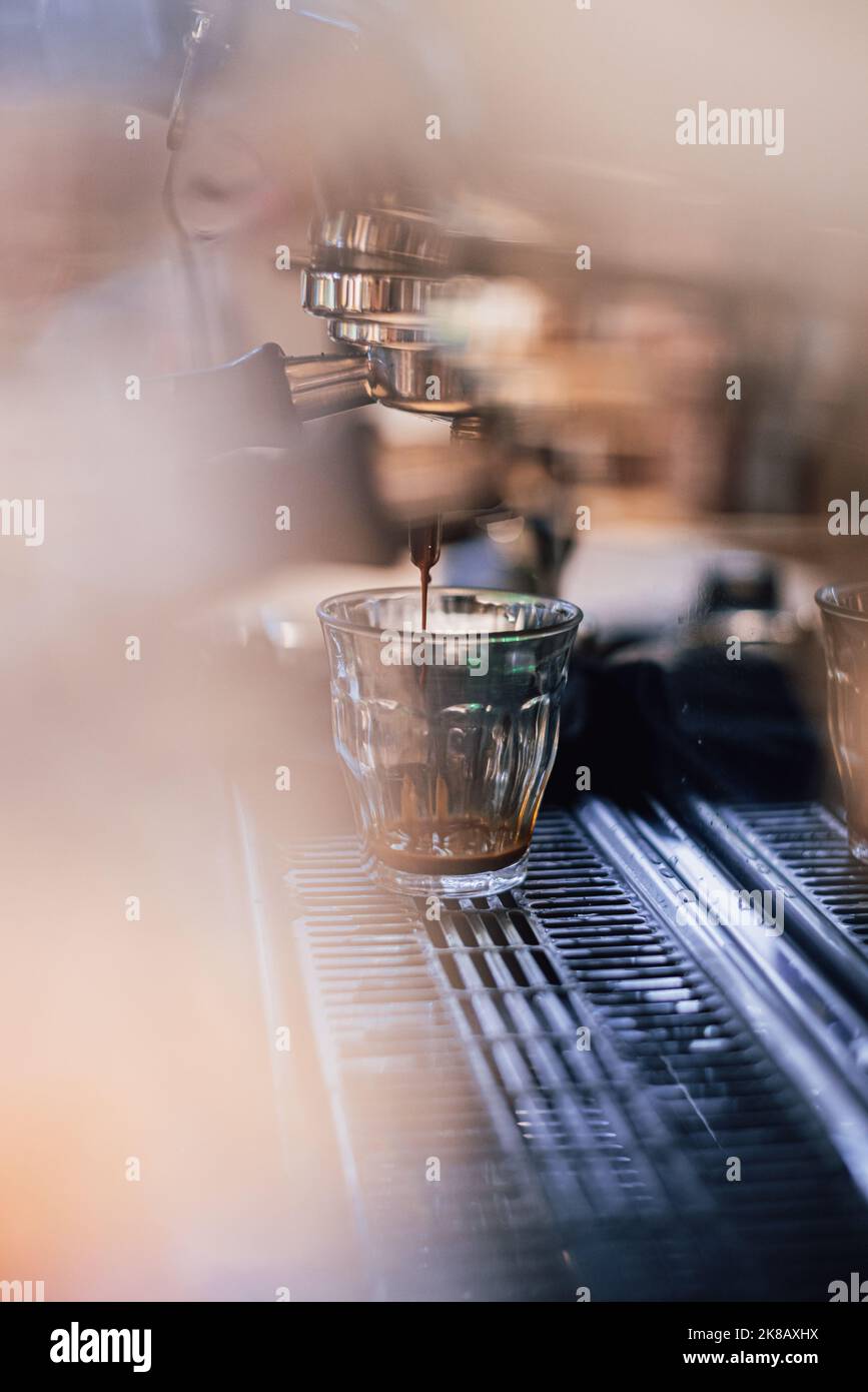Coffee dripping in a transparent glass from a coffee machine Stock ...