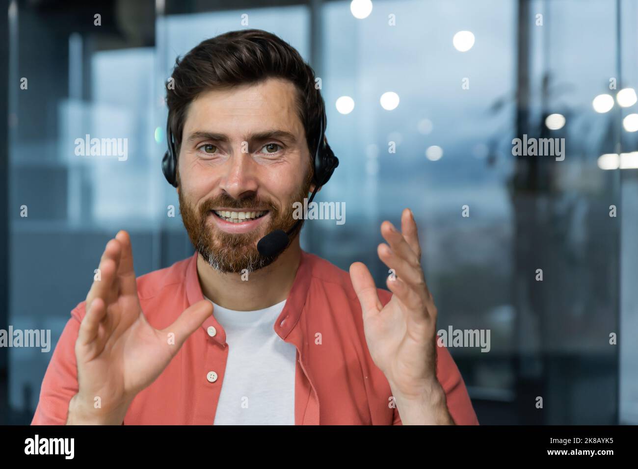 Close-up portrait of mature tech support worker looking at camera and ...