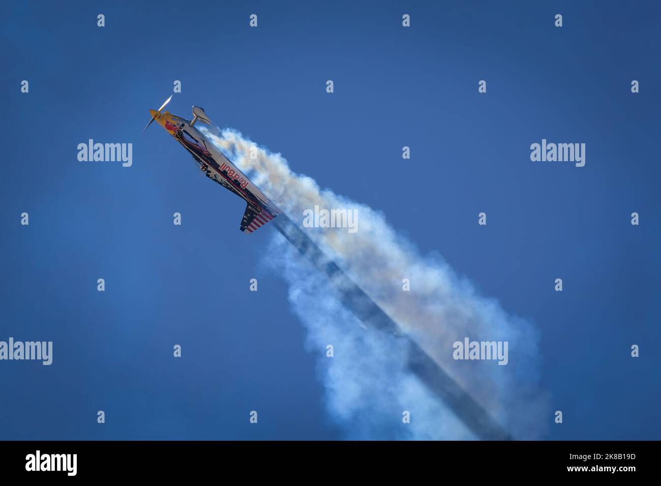 A stunt pilot with the Red Bull Air Force flies in to the sun, with ...