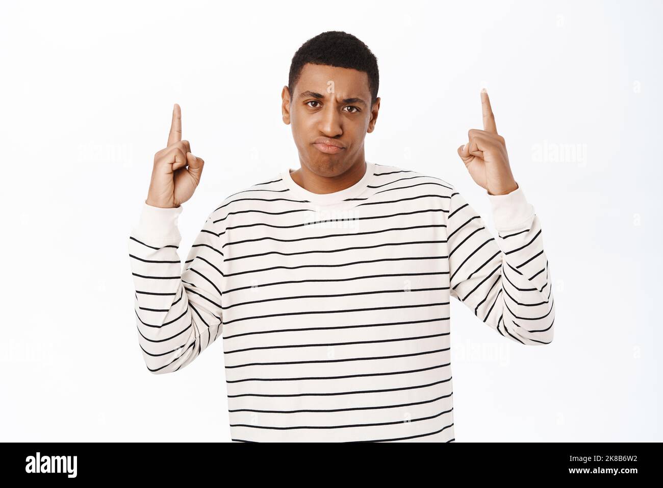 Annoyed african american man points up, sulks and looks bothered by ...