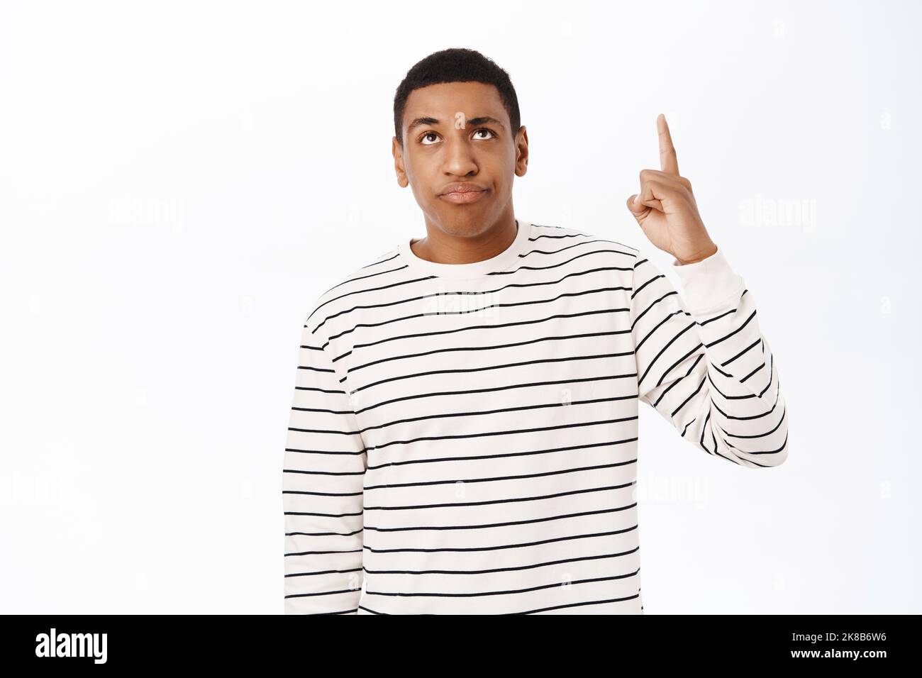 Annoyed african american man points up, sulks and looks bothered by ...