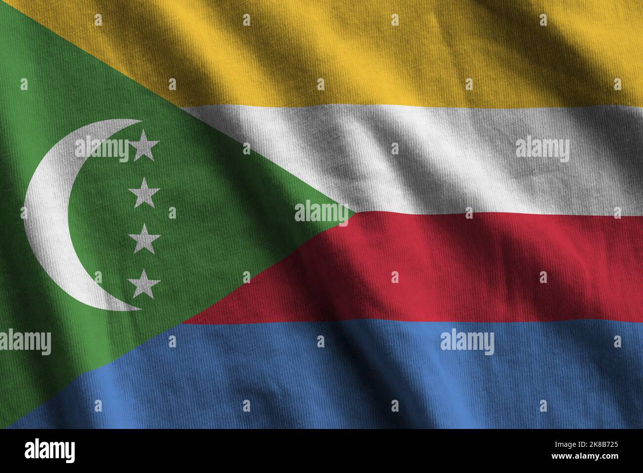 Comoros flag with big folds waving close up under the studio light ...