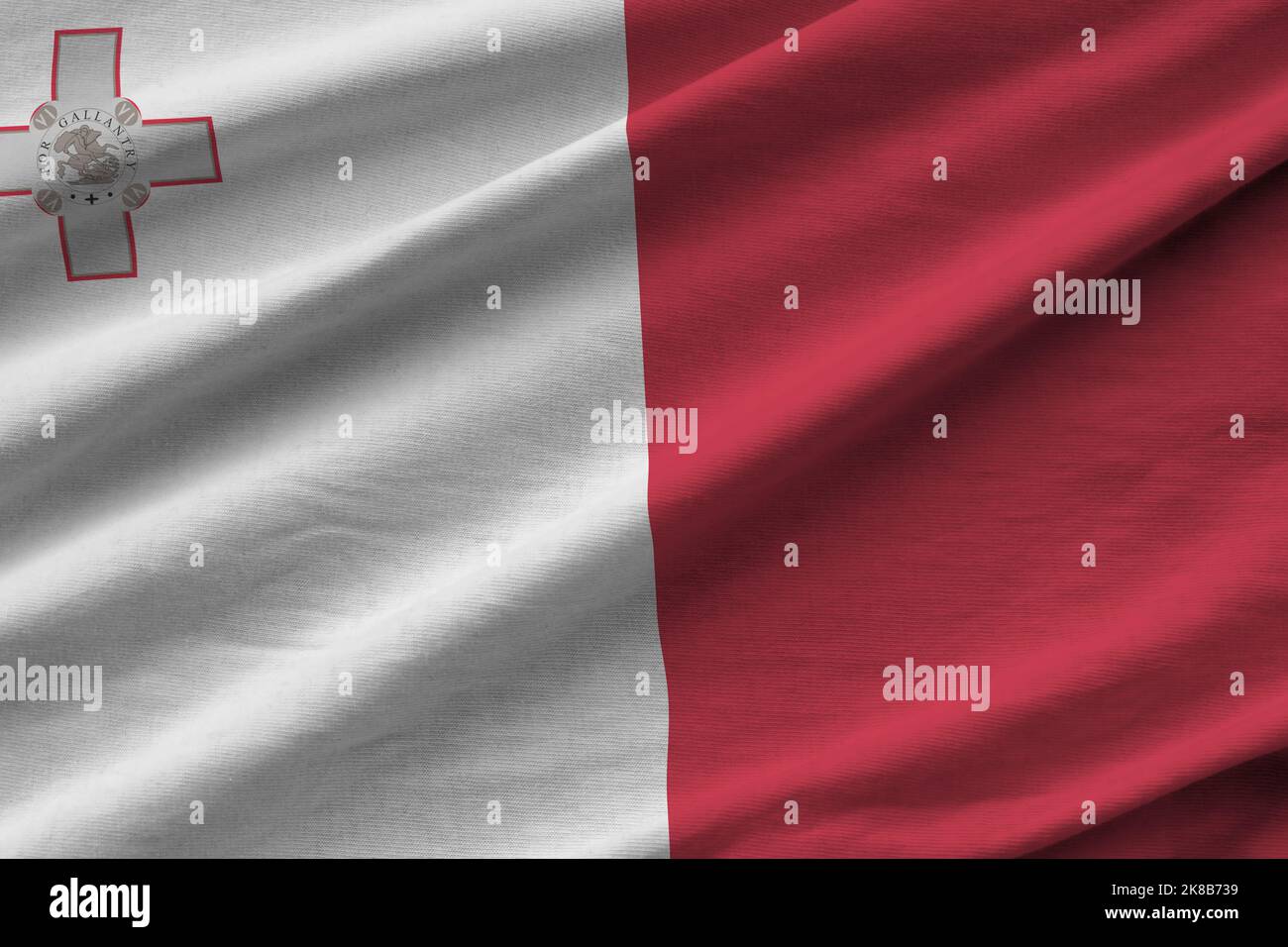 Malta flag with big folds waving close up under the studio light ...