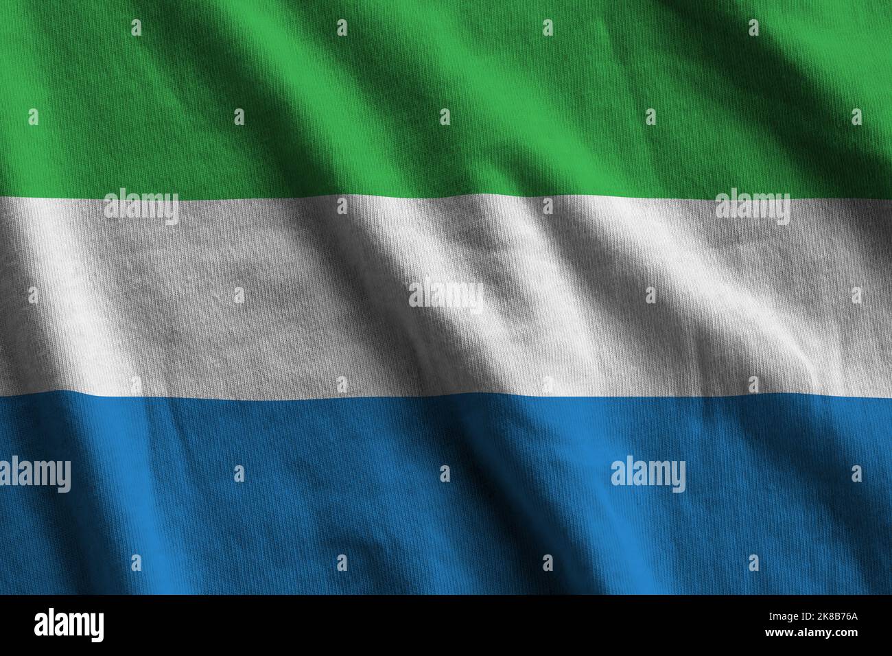 Sierra Leone flag with big folds waving close up under the studio light ...