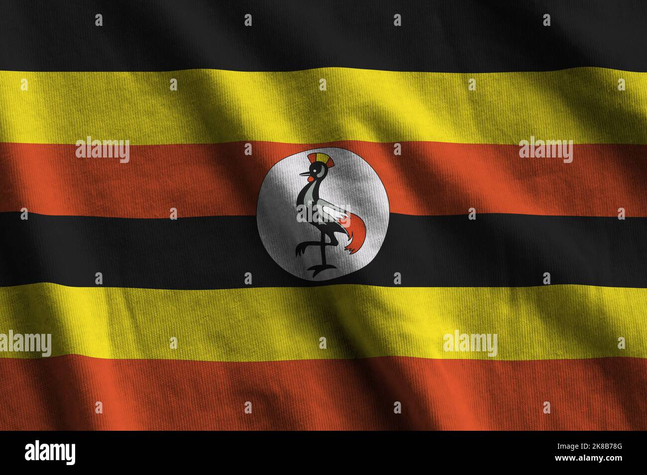 Uganda flag with big folds waving close up under the studio light ...