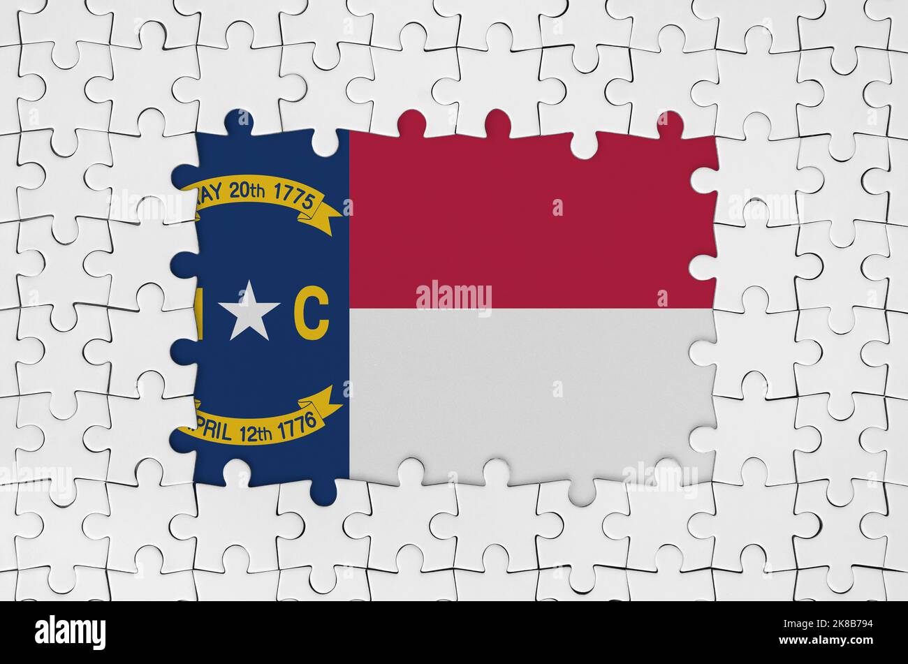 North Carolina US state flag in frame of white puzzle pieces with ...