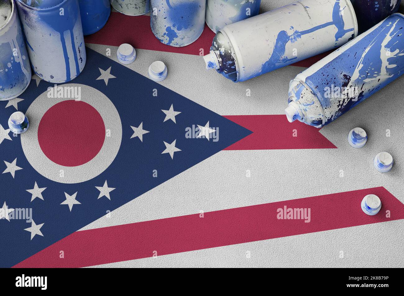 Ohio US state flag and few used aerosol spray cans for graffiti ...