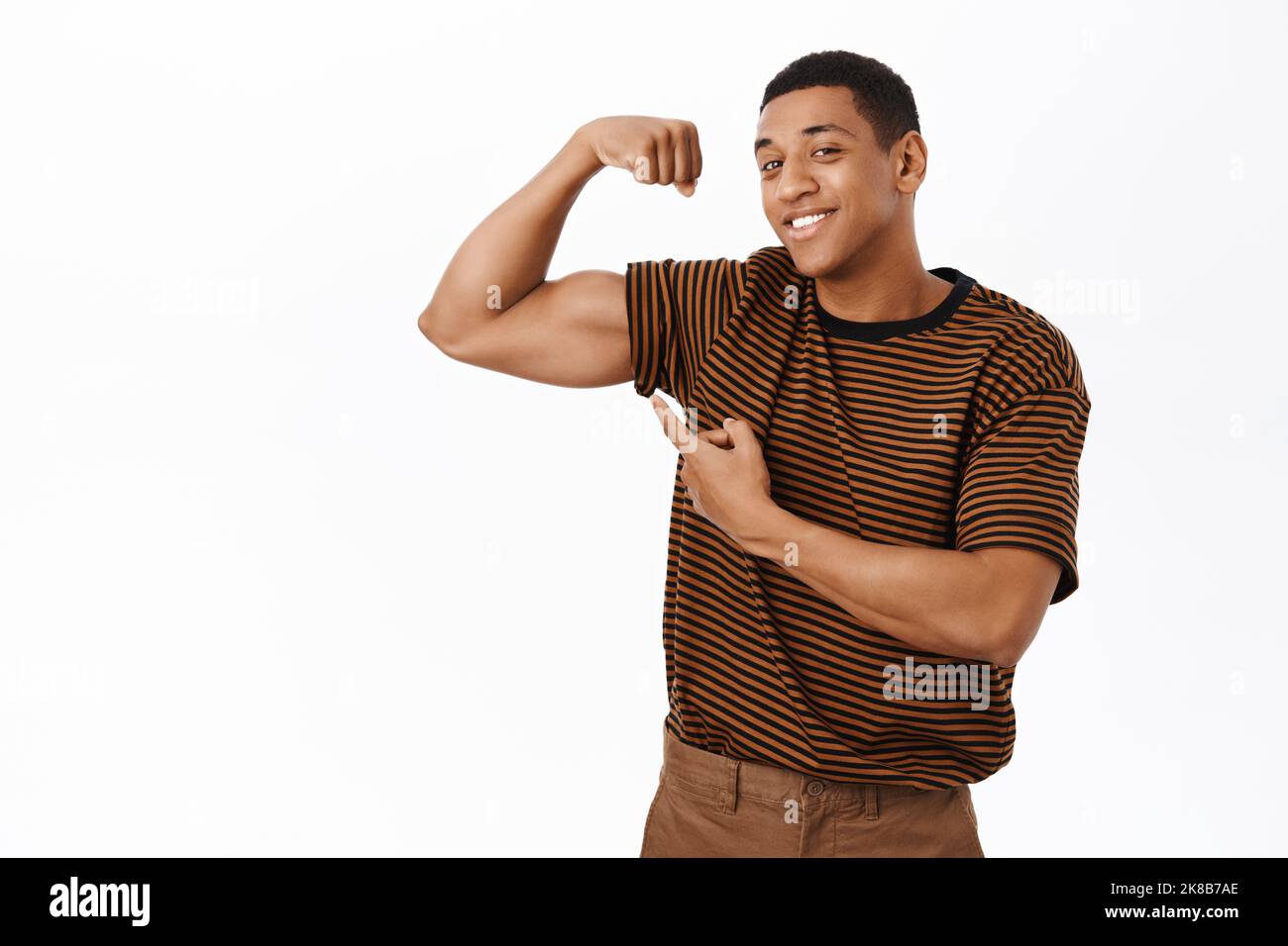 Sport and gym concept. Strong African american man flex biceps, shows ...