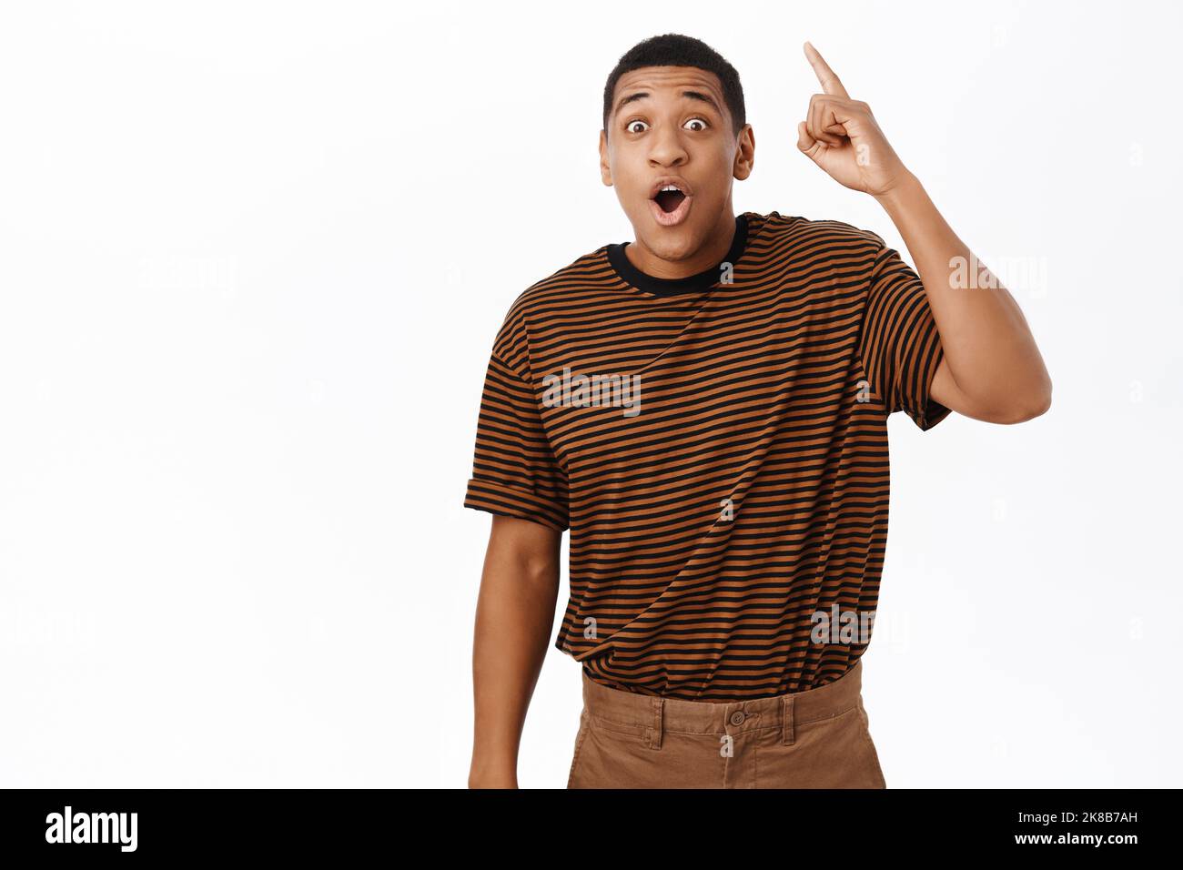 Excited African american man pointing up, looking amazed, pitching an ...
