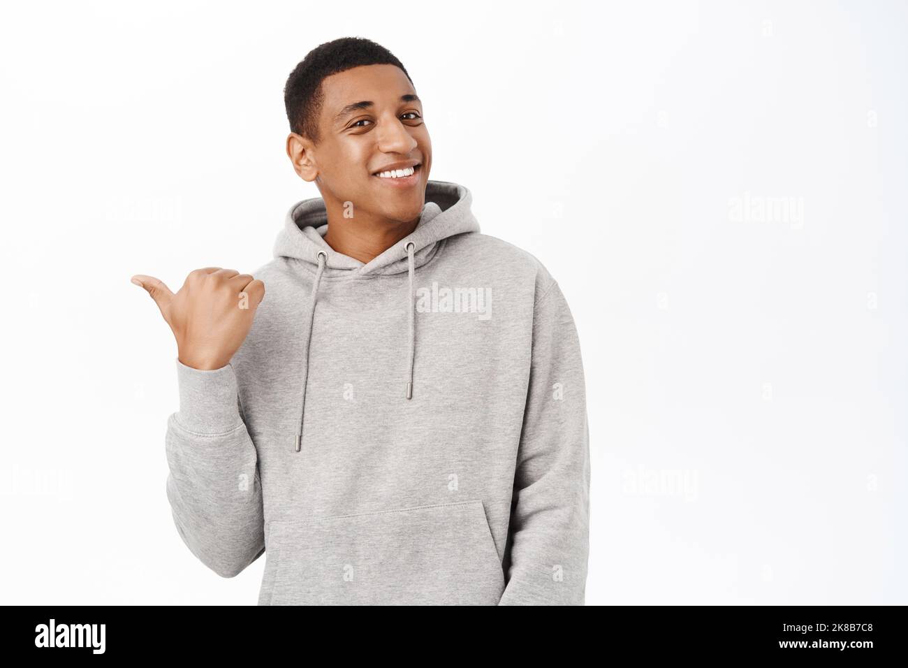 Portrait of smiling african american man pointing finger left, showing ...