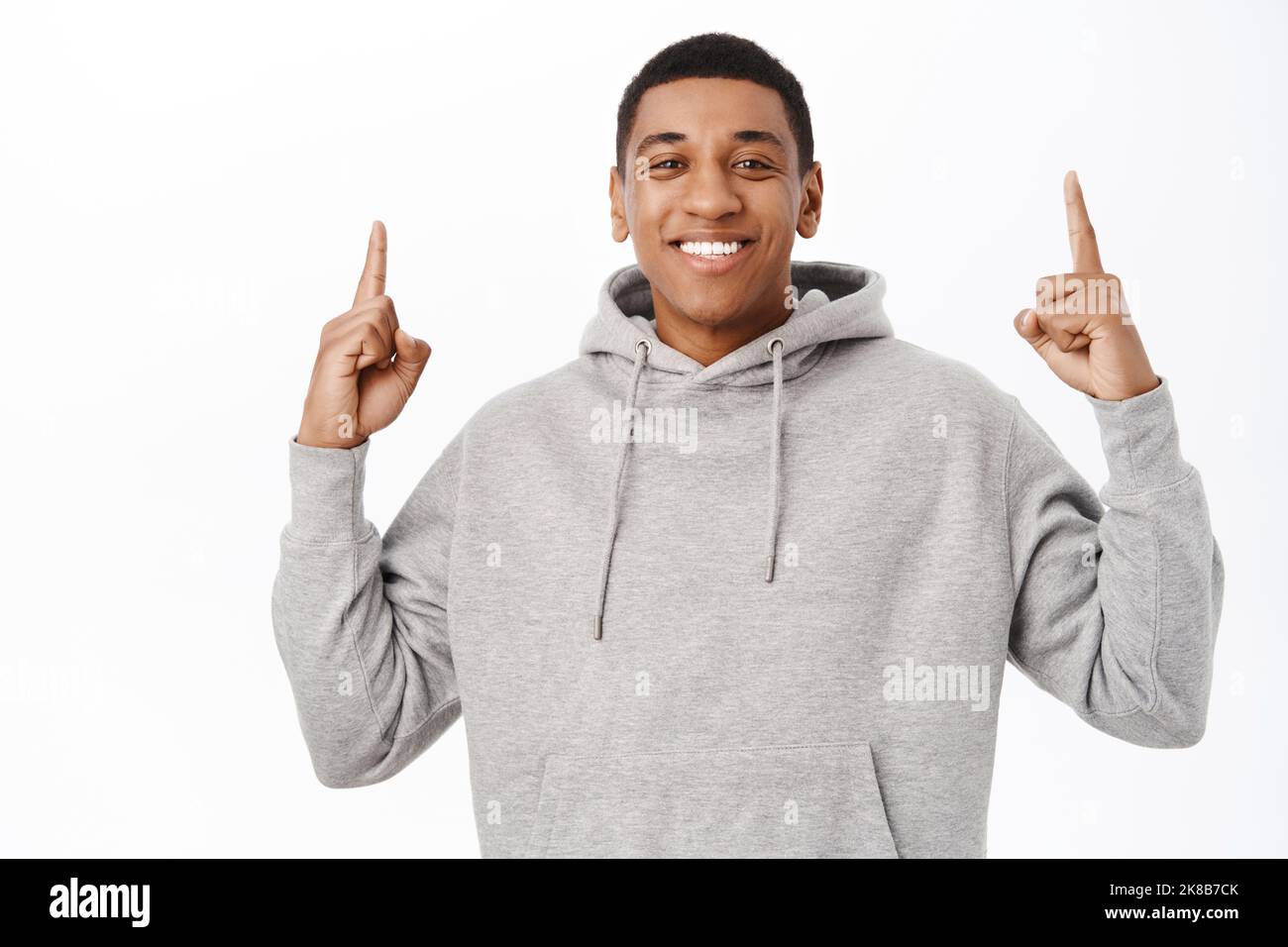Close up of smiling, happy Black man pointing fingers up, showing ...