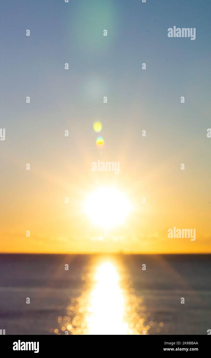 Blurred background. Sun shining in blue sky during sunset dawn. Sunrise ...