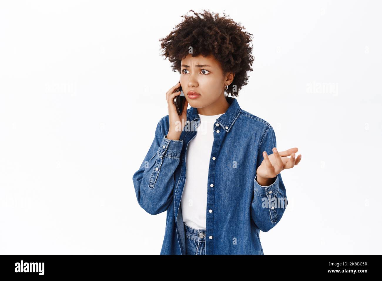 Woman talks on the phone with confused face. Girl answer call on ...