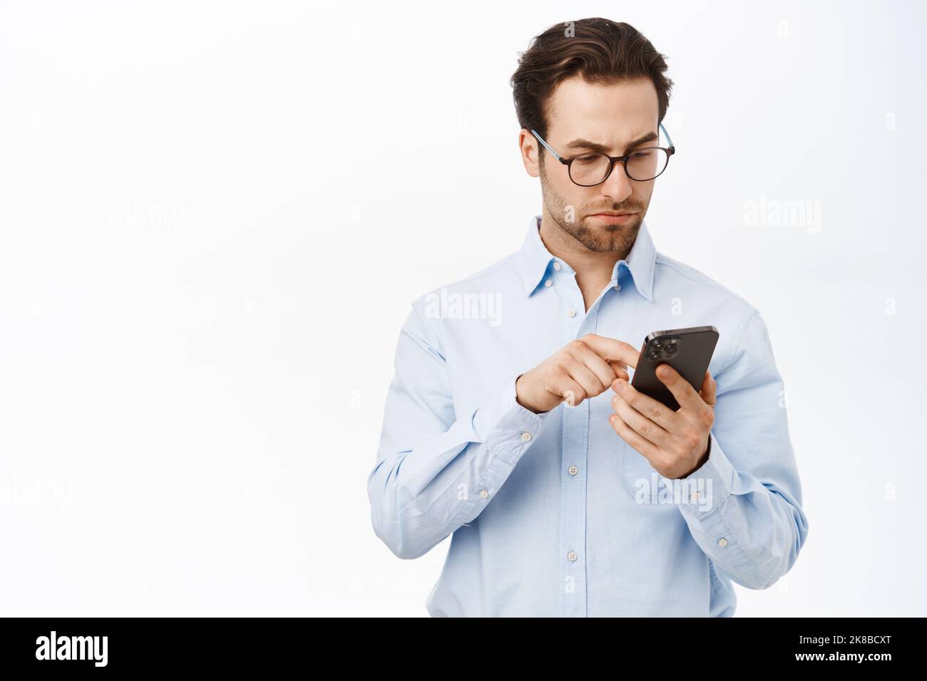 Portrait of handsome businessman using mobile phone, reading on ...