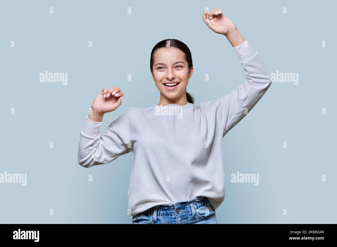 Cheerful dancing teenage girl on grey studio background Stock Photo - Alamy