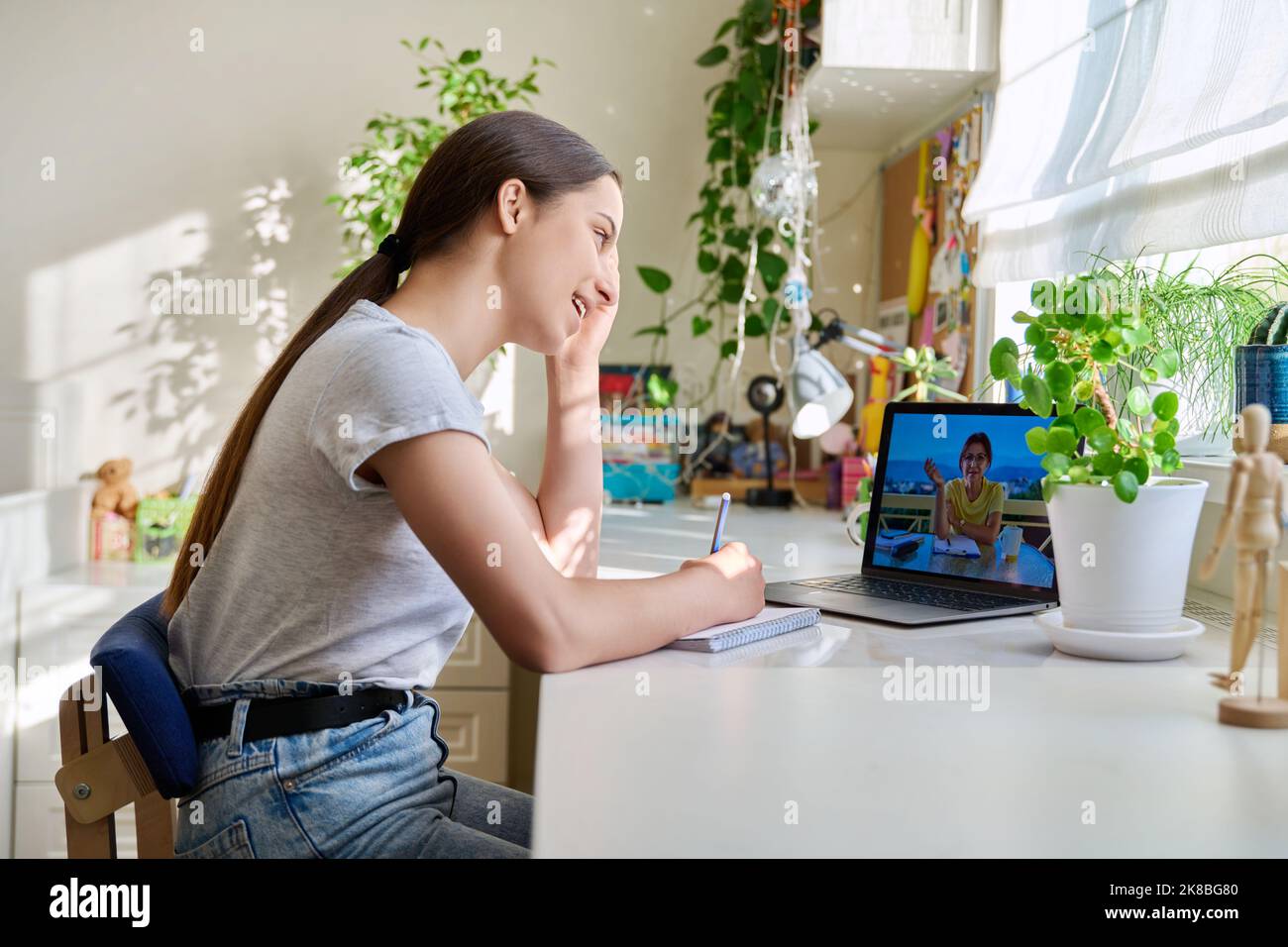 Adolescent teen girl looking at laptop screen, talking with teacher ...