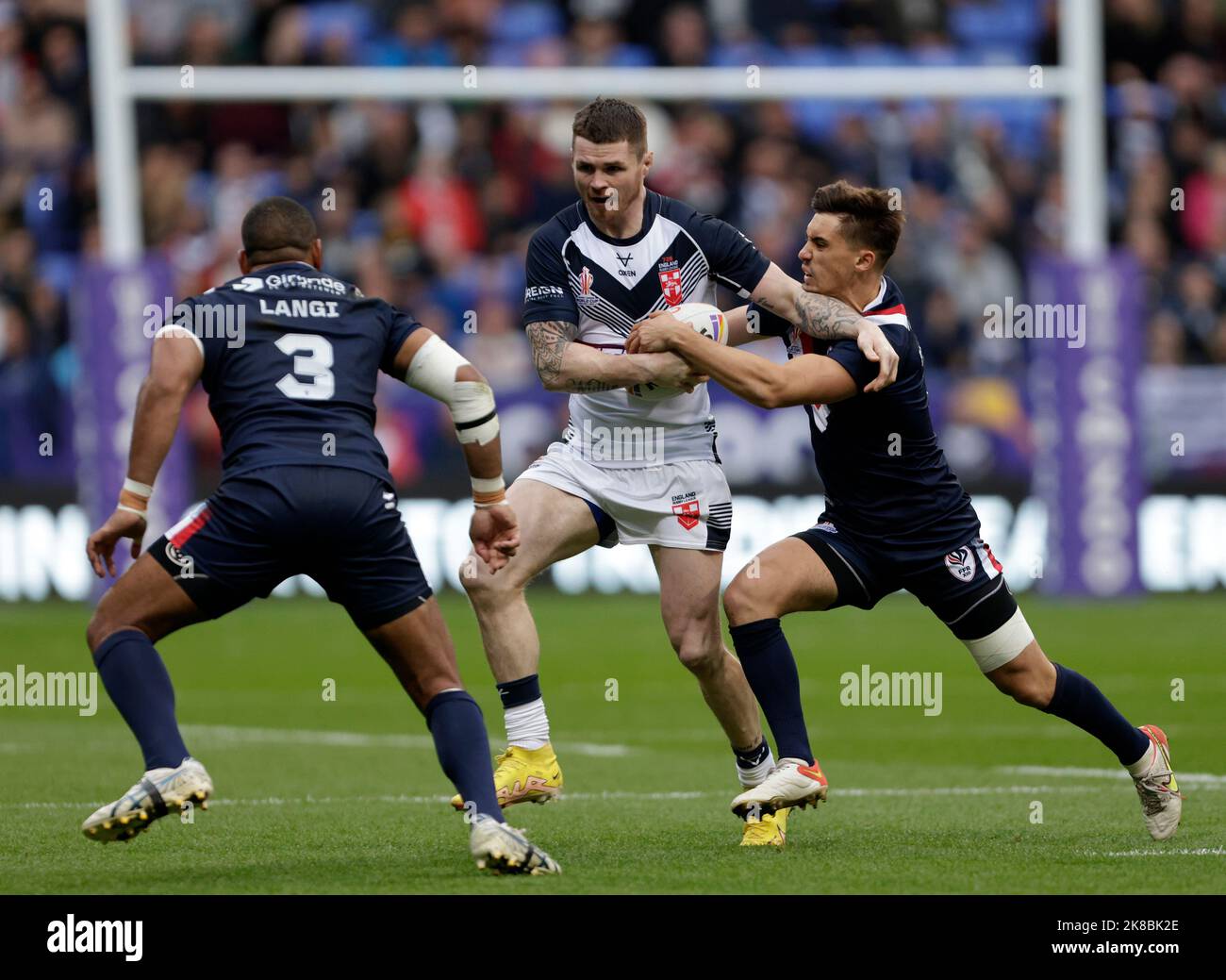 England's John Bateman (centre) is tackled by France's Samisoni Langi ...