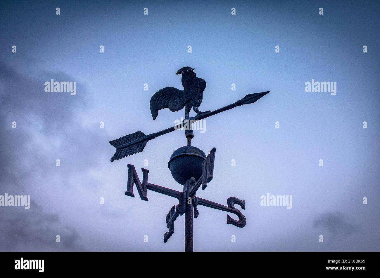 A weather van predicting a north-easterly wind Stock Photo - Alamy