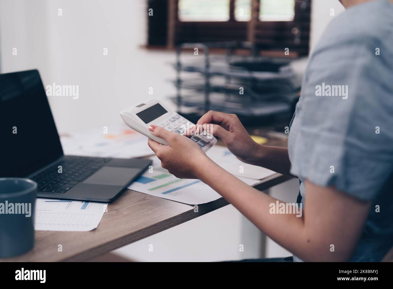 Asian Business Woman or Accountant do math and analyze with calculator ...