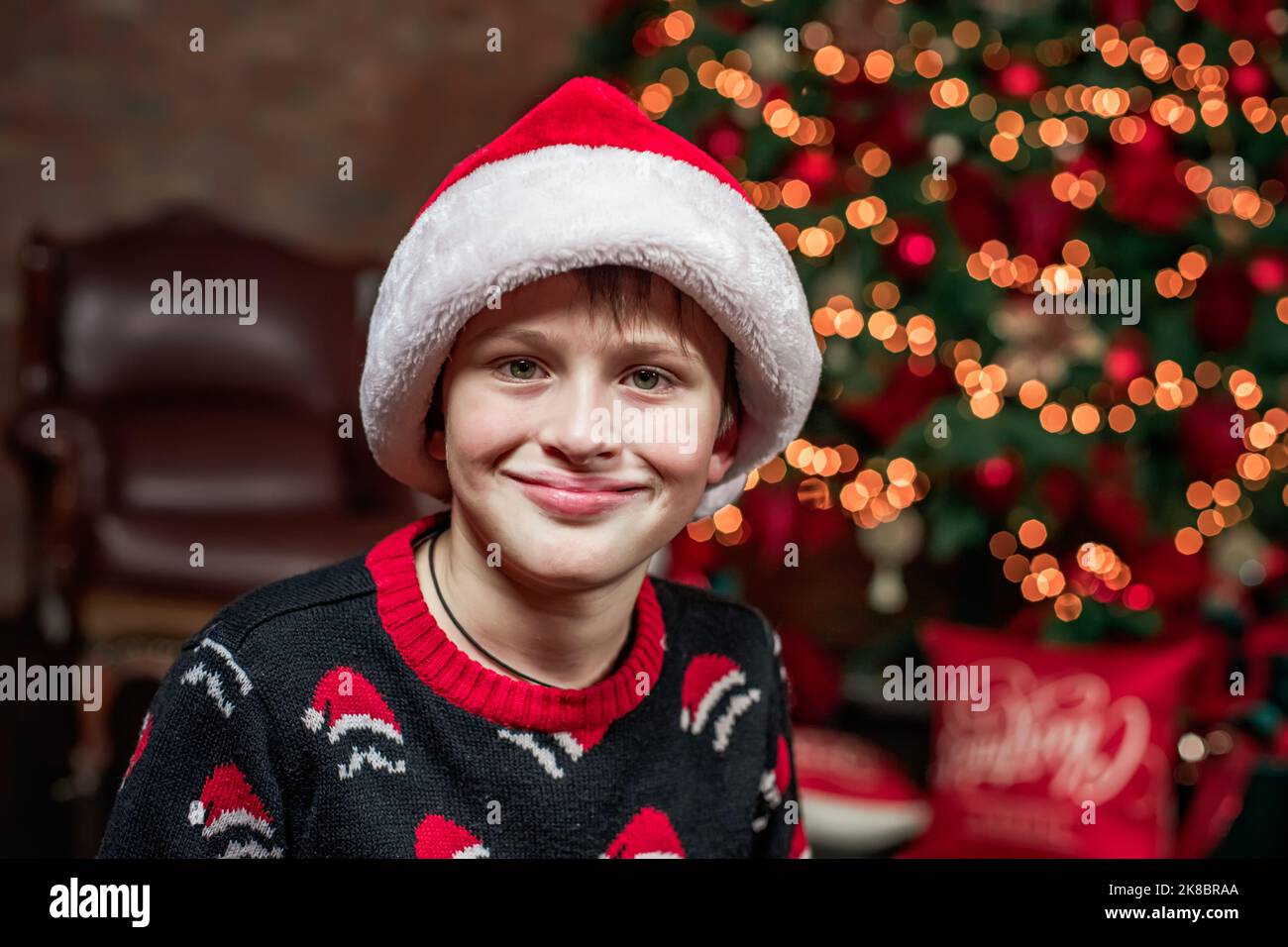 A boy in Santa Claus hat in the background of the lights of the ...