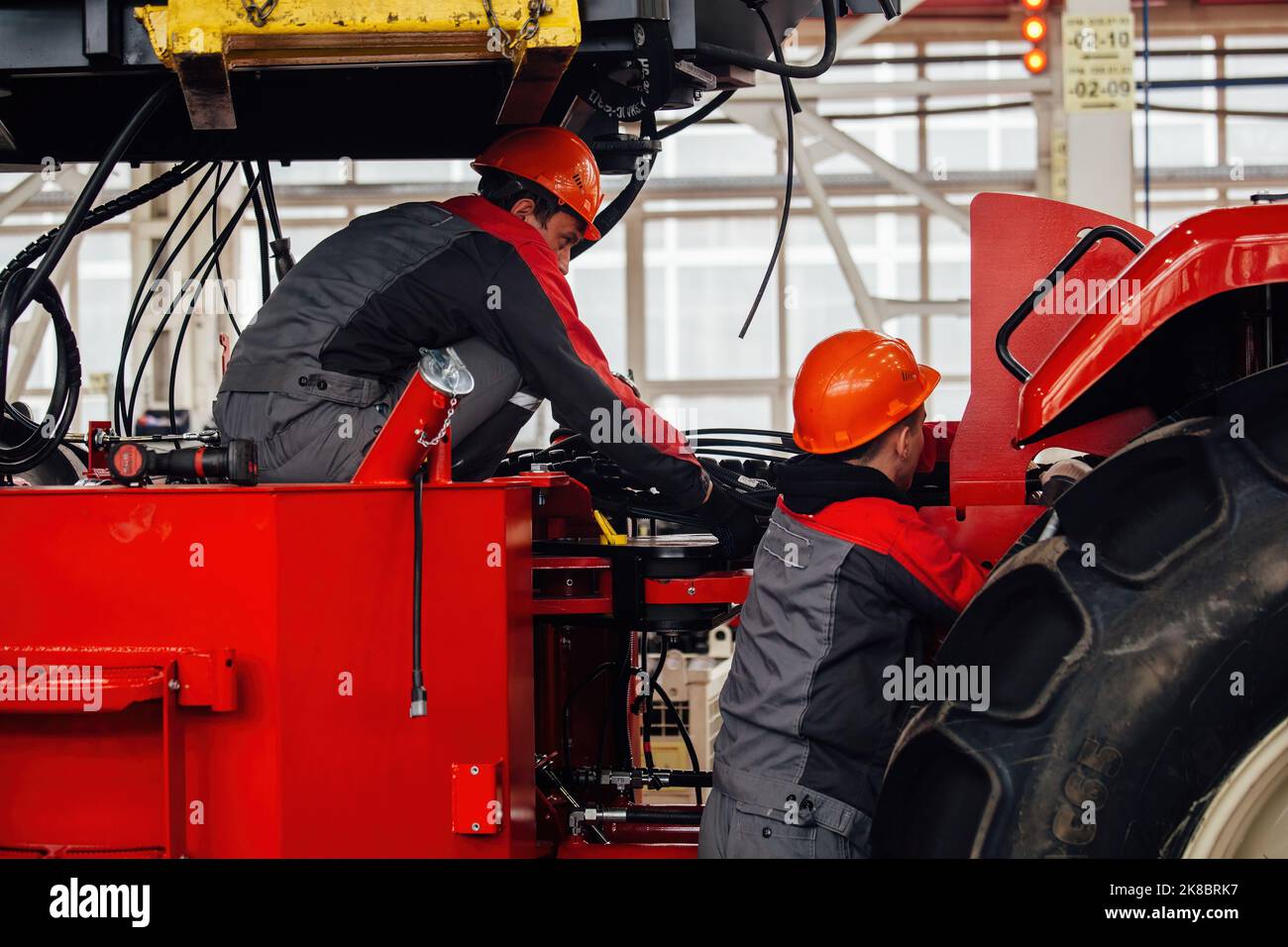 Industrial workers assembles agricultural tractor in workshop Stock ...