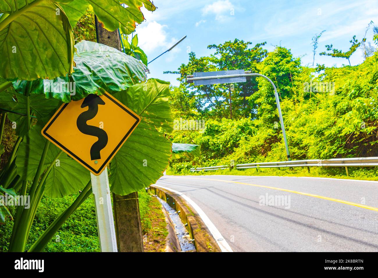 Yellow typical Asian street road sign in Naithon Beach on Phuket Island ...