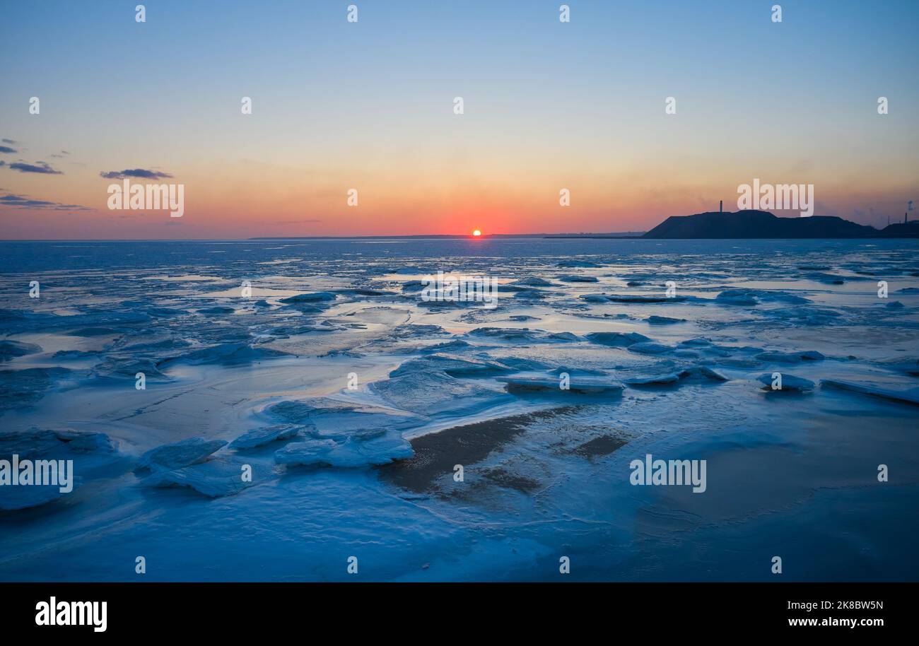 Aerial view of sunset over the frozen sea. Winter landscape on seashore ...