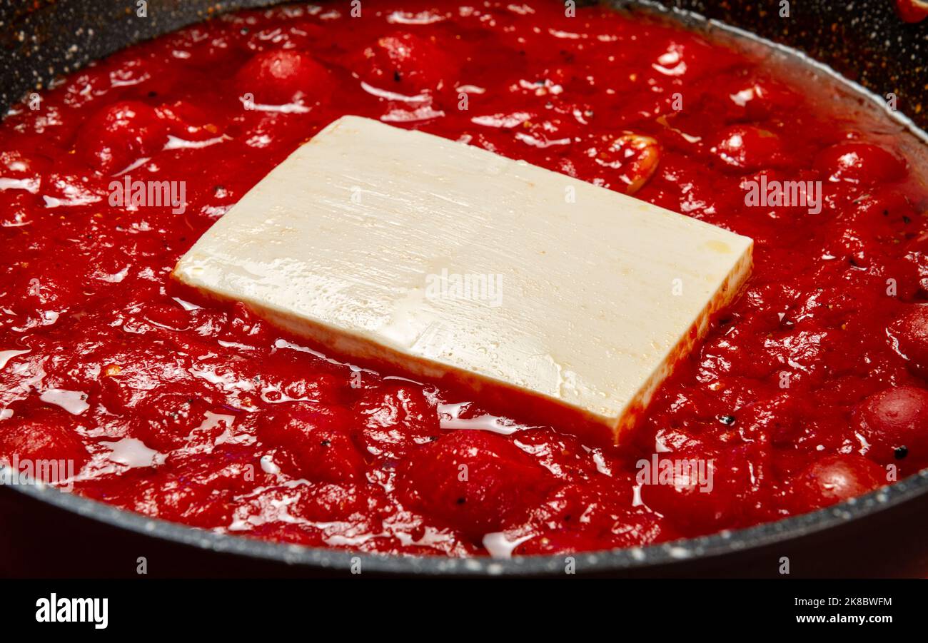 block of feta cheese in canned tomatoes Stock Photo - Alamy