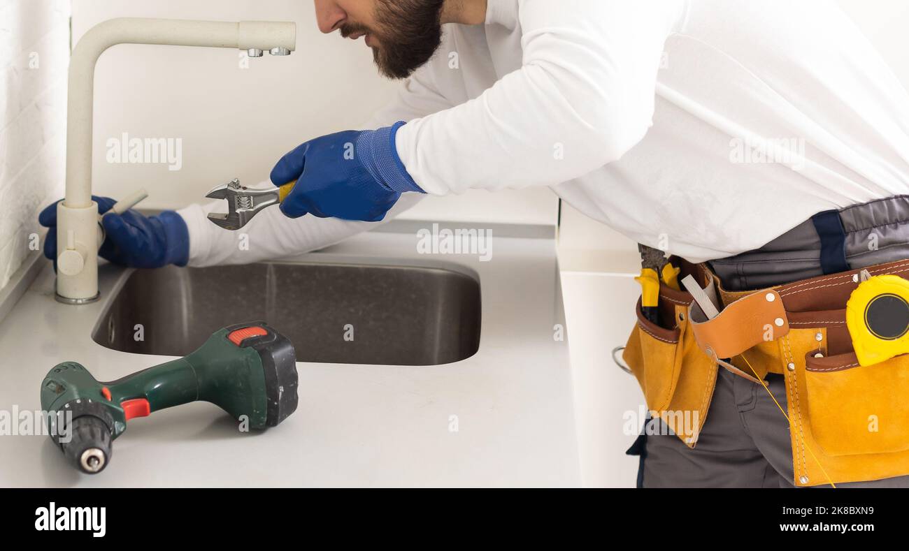 Male Plumber In Overall Fixing Sink Stock Photo - Alamy
