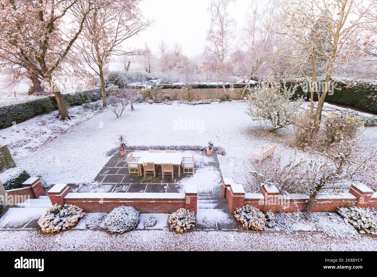Snow covered garden in winter, UK. Large country backyard or garden in ...