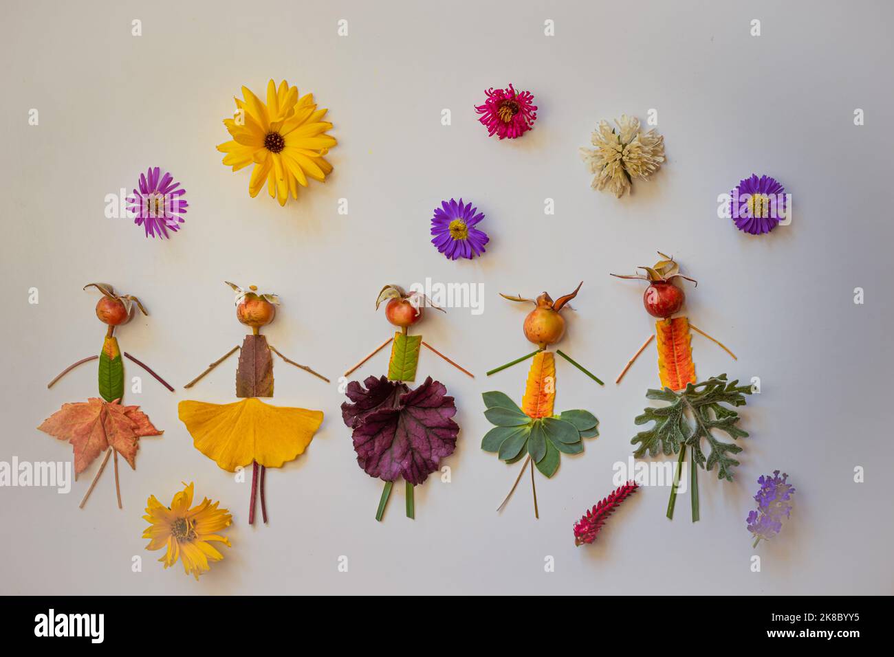 cute figures, dancers made from colorful leaves and bright flowers on ...