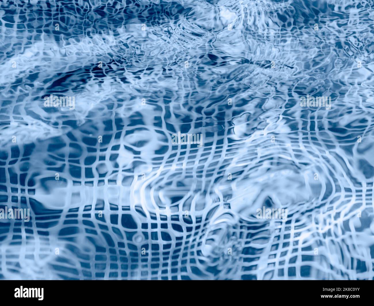 Surface of water in swimming pool or fountain with blue mosaic bottom ...