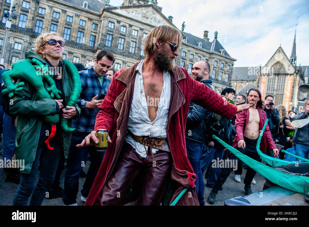A man wearing strange clothes is seen dancing behind one of the trucks ...