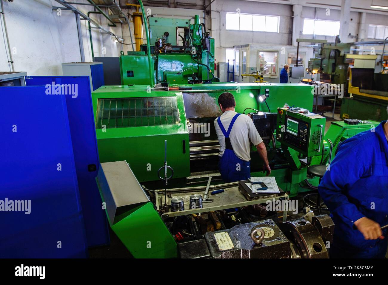 Factory engineer adjusting operation parameters of CNC lathe machine ... Factory engineer adjusting operation parameters of CNC lathe machine ...
