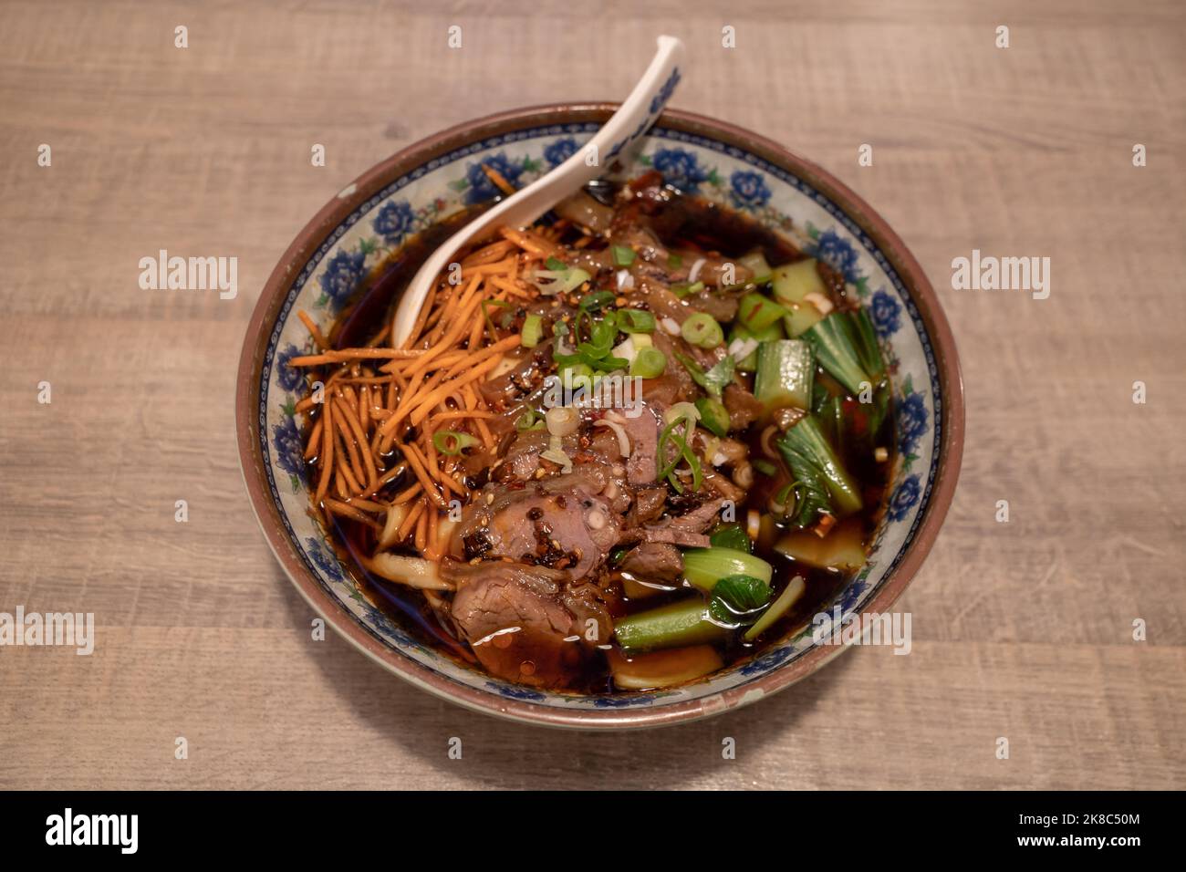 Chinese Spicy goulash Beef Noodle Soup on wooden counter table Stock ...