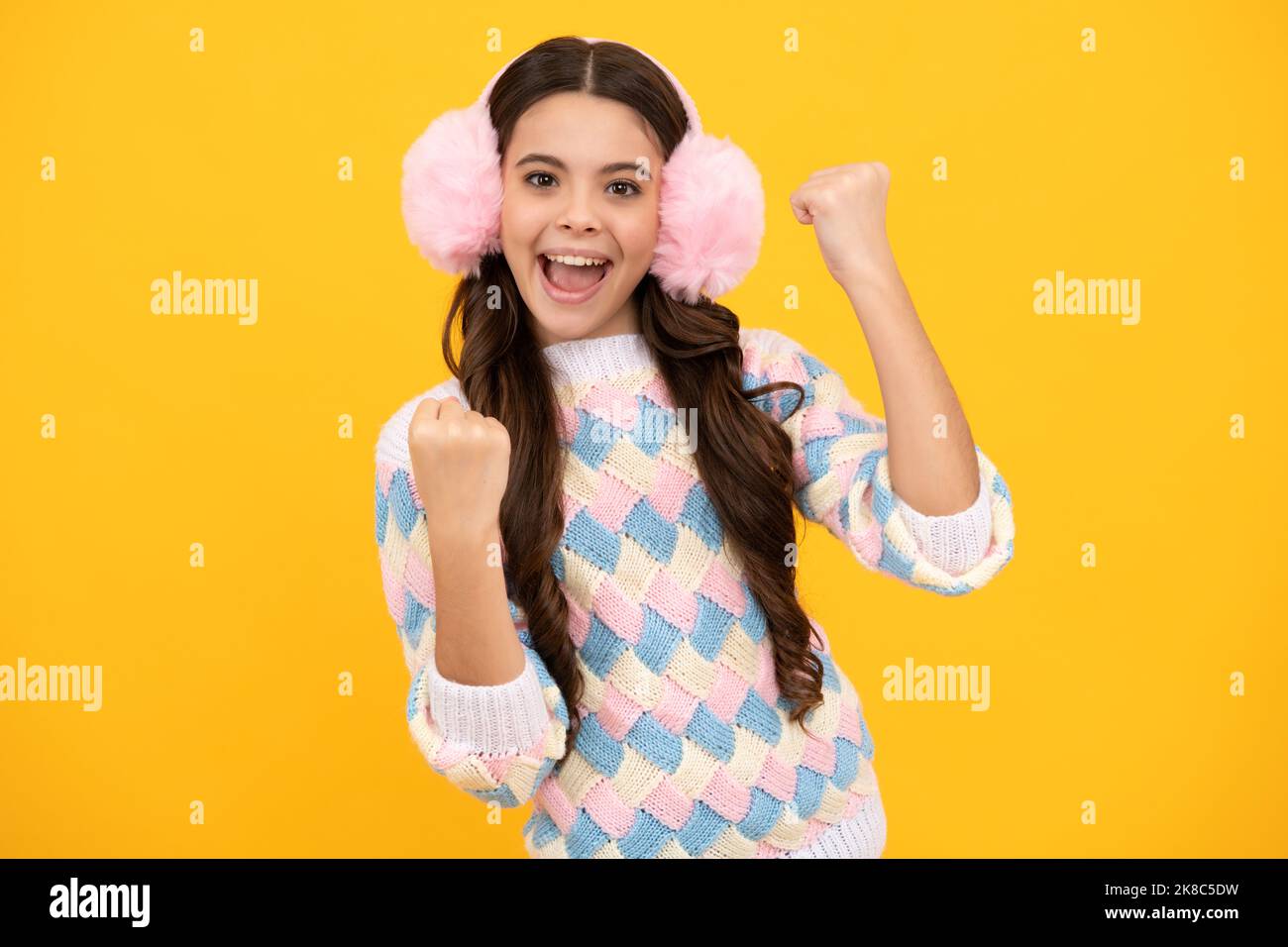 Excited face. Beautiful teen girl in a winter warm earmuff ear-flaps ...