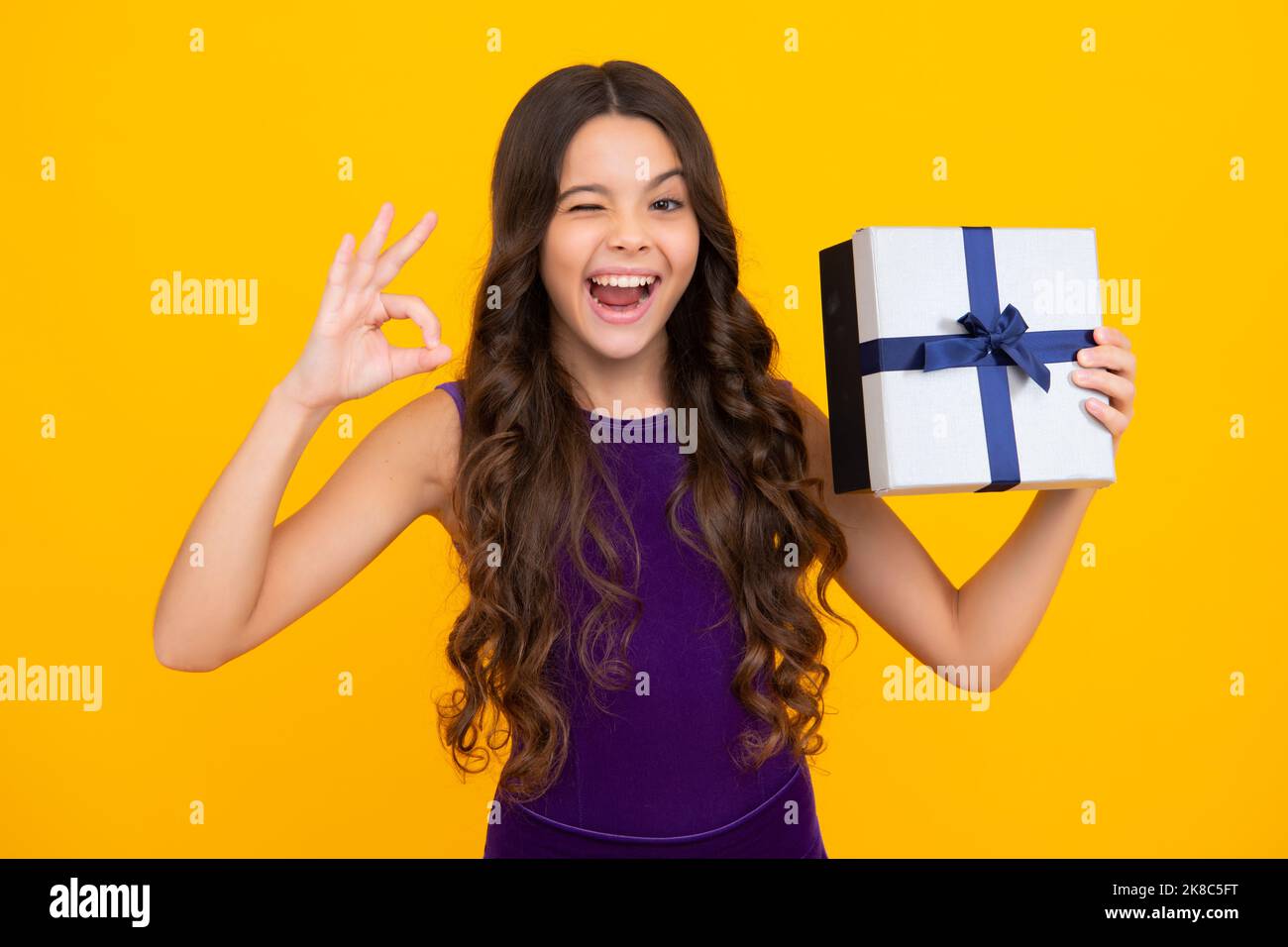 Funny face. Teenager kid with present box. Teen girl giving birthday ...