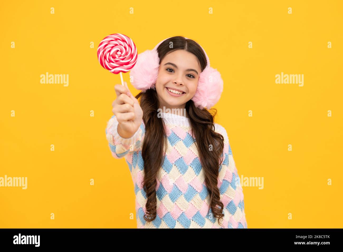 Cool teen child with lollipop over yellow isolated background. Sweet ...