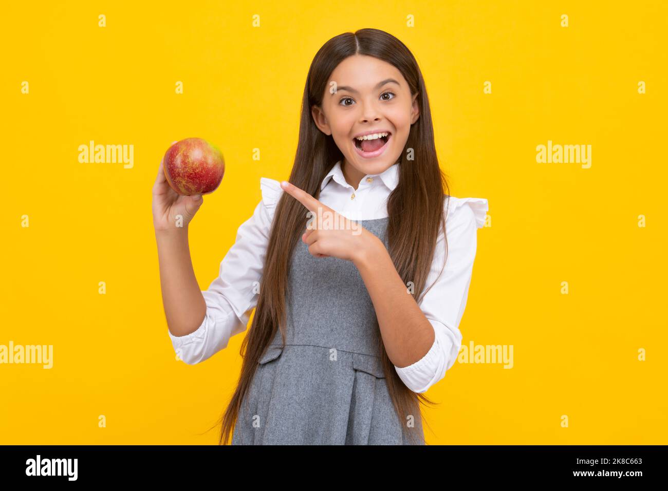 boy eating green apple on yellow isolated background. apples are good ...