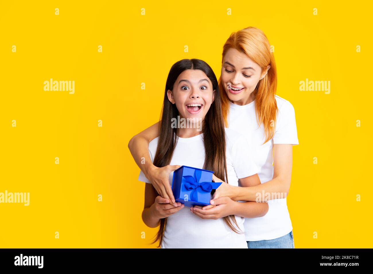 Child teen girl giving present to excited amazed mother isolated on ...