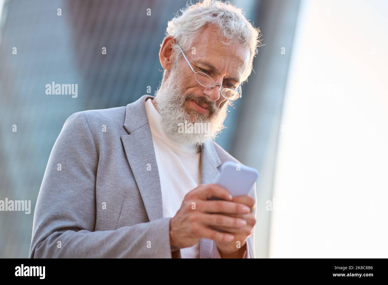 Old senior professional business man holding phone using smartphone ...