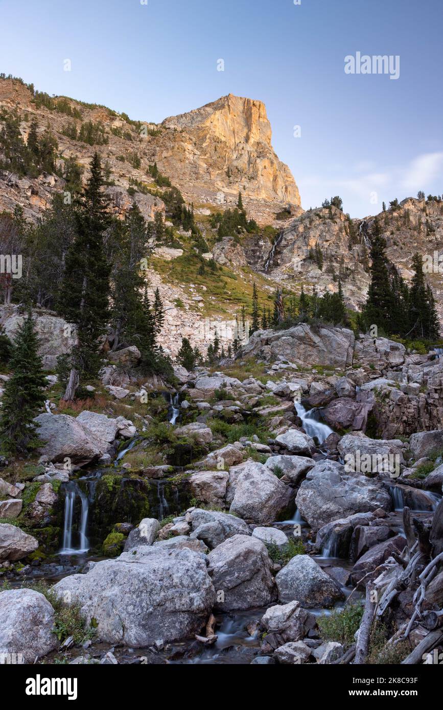 Waterfalls pouring over rocks and boulders below steep peaks in the South Fork of Cascade Canyon ...