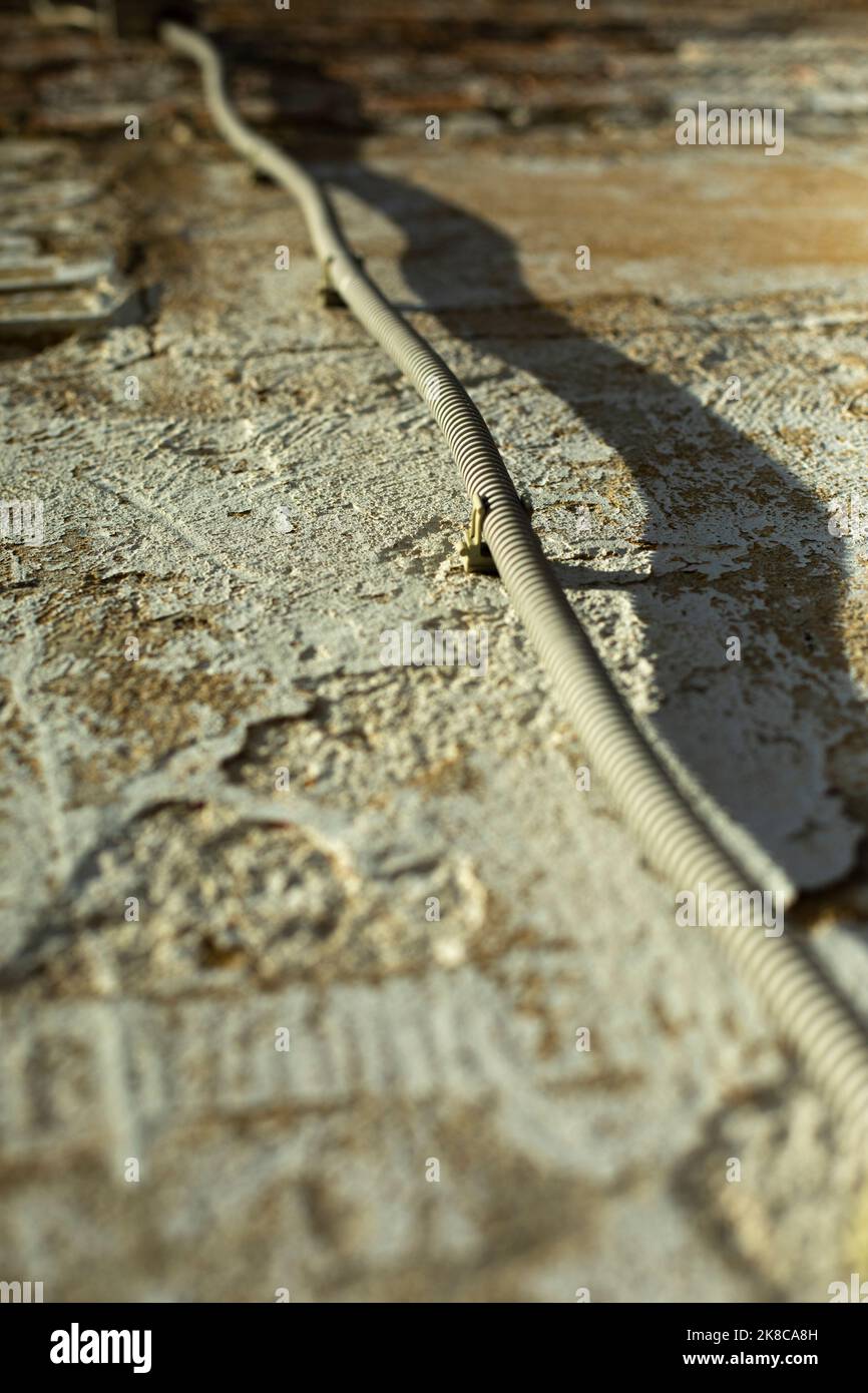 Cable on wall. Wire is insulated and fixed on building. Wiring parts ...