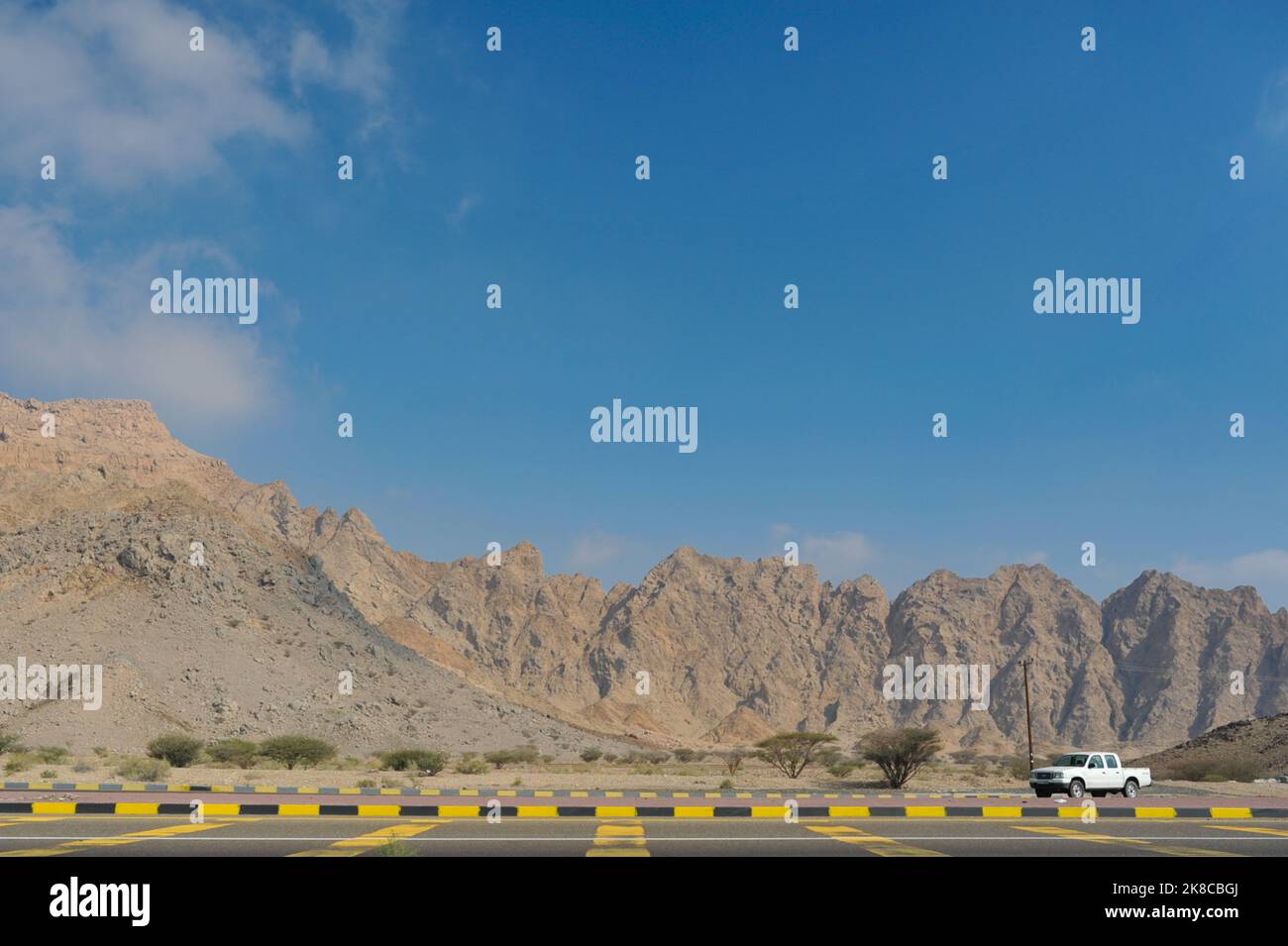 Road in Hatta, an inland exclave of Dubai, UAE. White pick-up on the ...