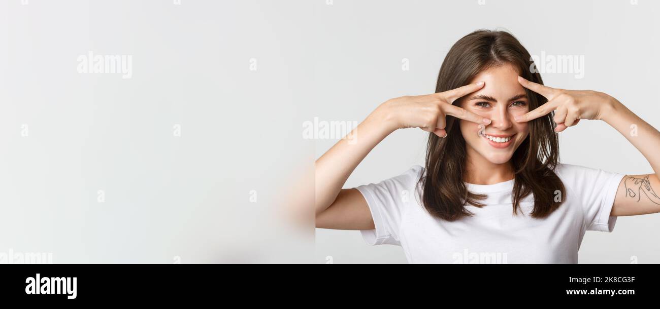 Close-up of sassy attractive brunette girl showing peace gestures over ...