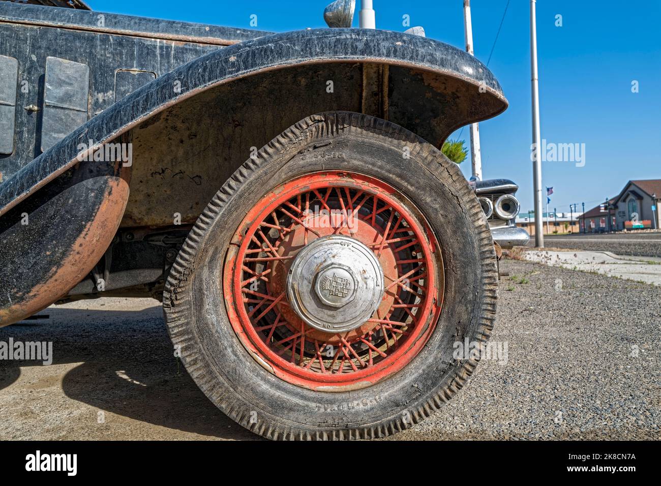 Detail of the red wire rim wheel and tire of an antique Cadillac in a ...