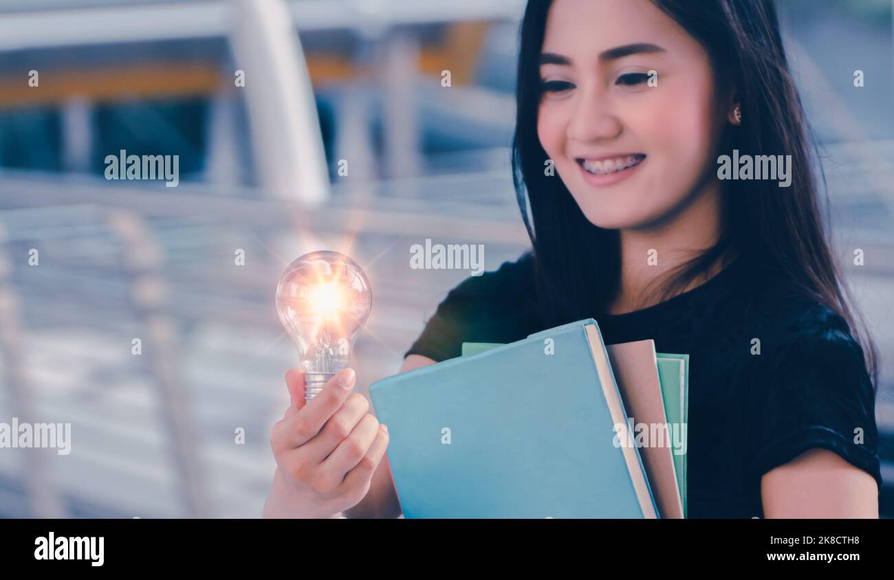 Young university student holding light bulb,creative idea, Thoughts ...