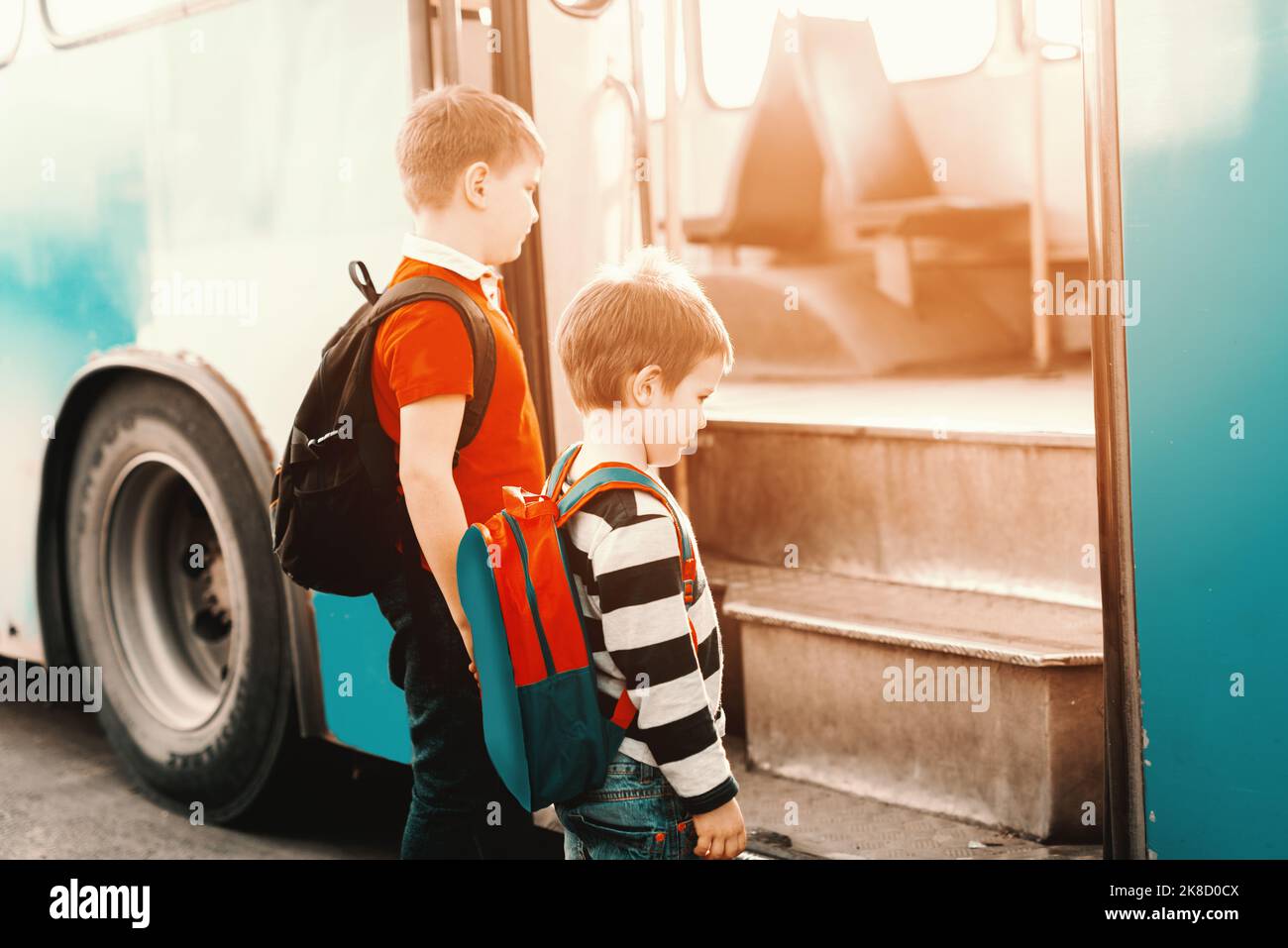 Brothers entering the city bus and going to school. Side view Stock ...