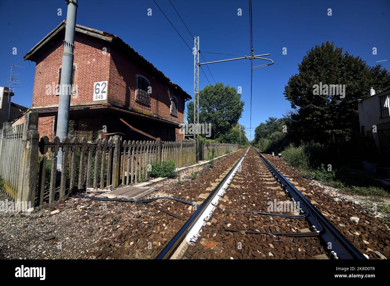 Railroad crossing with trees and buildings by its side at sunset Stock ...